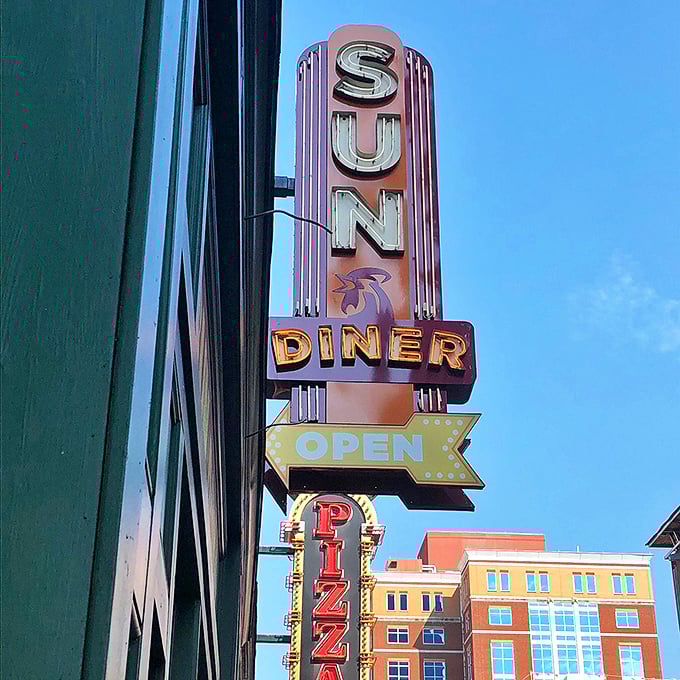 The retro neon sign beckons hungry passersby like a beacon of breakfast hope—a glowing promise of comfort food and musical nostalgia.