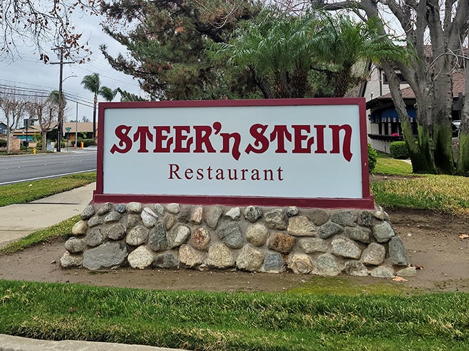 The roadside sign, perched atop a bed of river rocks, stands as a beacon for hungry travelers and locals alike—simple, direct, and promising satisfaction.