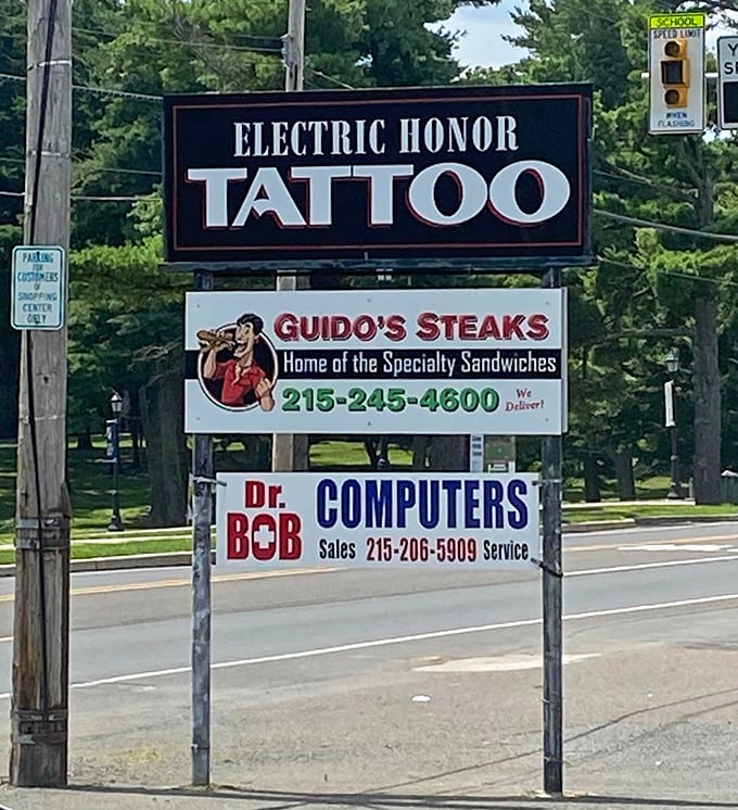 The roadside sign shares space with tattoo artists and computer repair – a perfect Pennsylvania strip mall trifecta of essential services.