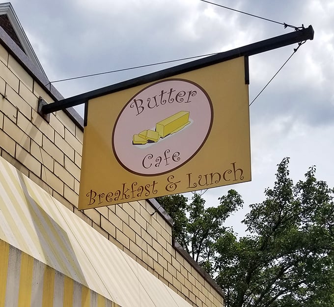 The charming sign swinging above the yellow awning is like a beacon for breakfast lovers—follow it to find your morning bliss.