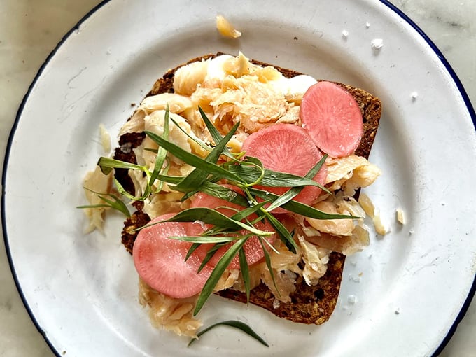 Smoked trout toast adorned with radish medallions and microgreens—like jewelry for your lunch, except you get to eat it when you're done admiring.