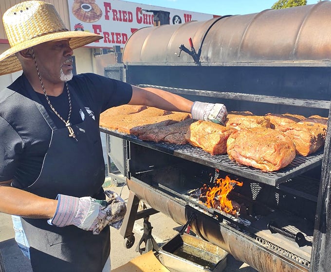 The pitmaster at work—part scientist, part artist, all dedication. This is barbecue as religion, and the smoker is the altar.