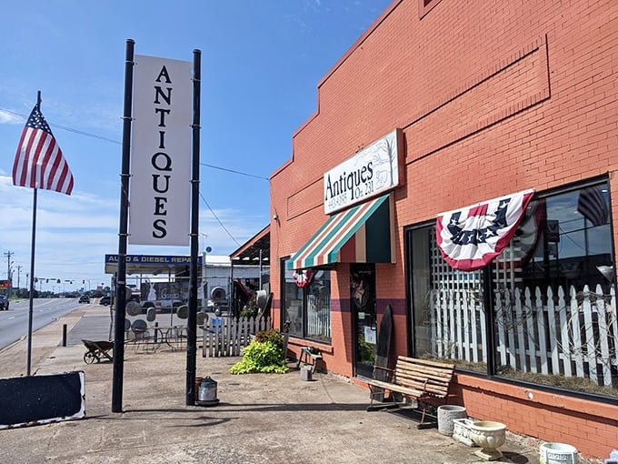 The American flag and vertical "ANTIQUES" sign serve as beacons for treasure hunters traveling Highway 231, promising discoveries worth the detour.