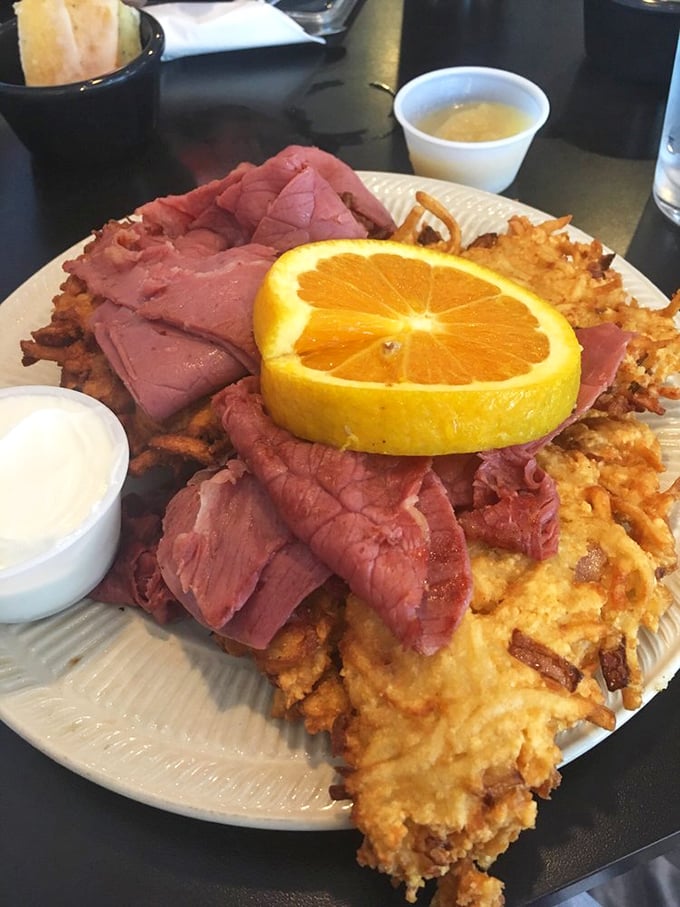 The Schmoozer isn't just a sandwich—it's a monument to excess, where corned beef lounges atop crispy potato pancakes like it's on vacation.