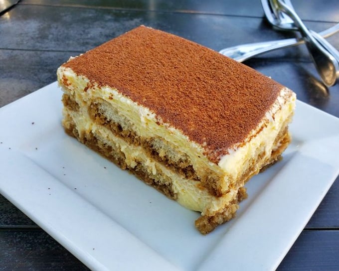 This isn't tiramisu—it's galaktoboureko's sophisticated cousin, layers of custard and soaked cake dusted with cinnamon that demands to be savored slowly.