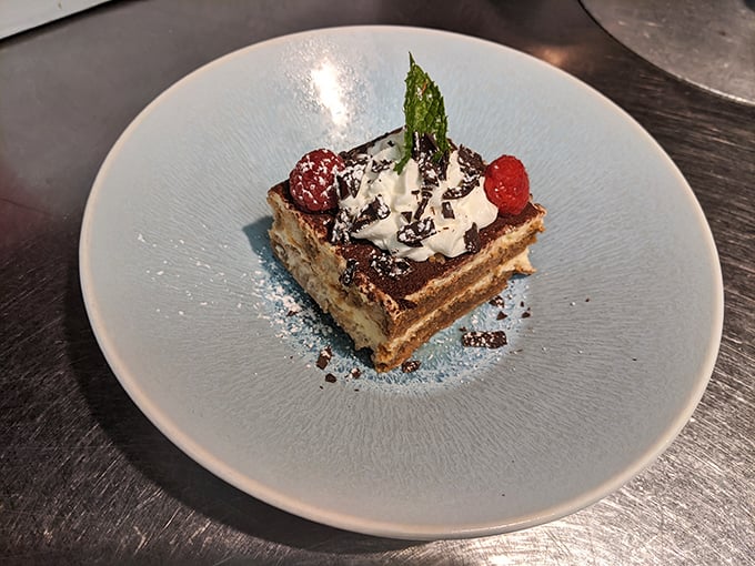 The tiramisu arrives looking like it graduated with honors from Italian Dessert Academy – layers of coffee-soaked perfection topped with just enough cocoa.