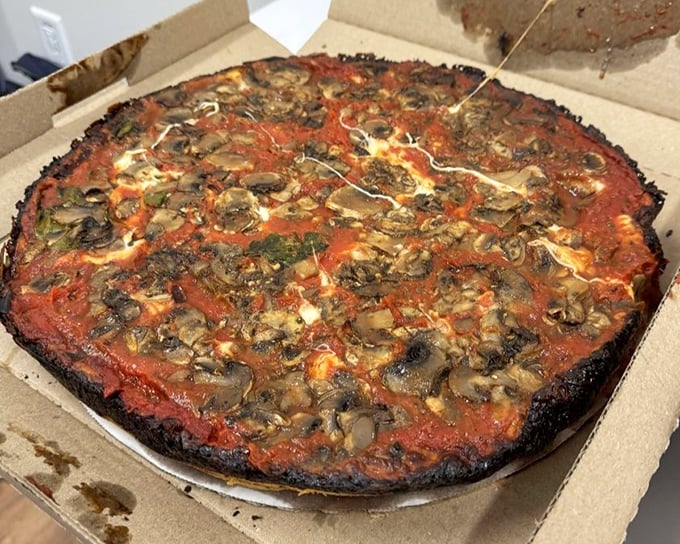 A mushroom lover's dream – fungi finding their perfect home atop that signature sauce and beneath that blackened cheese halo.