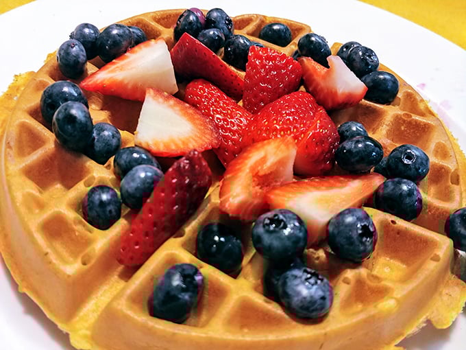A golden waffle becomes the perfect landing pad for a squadron of blueberries and strawberries – fruit that actually tastes like fruit.