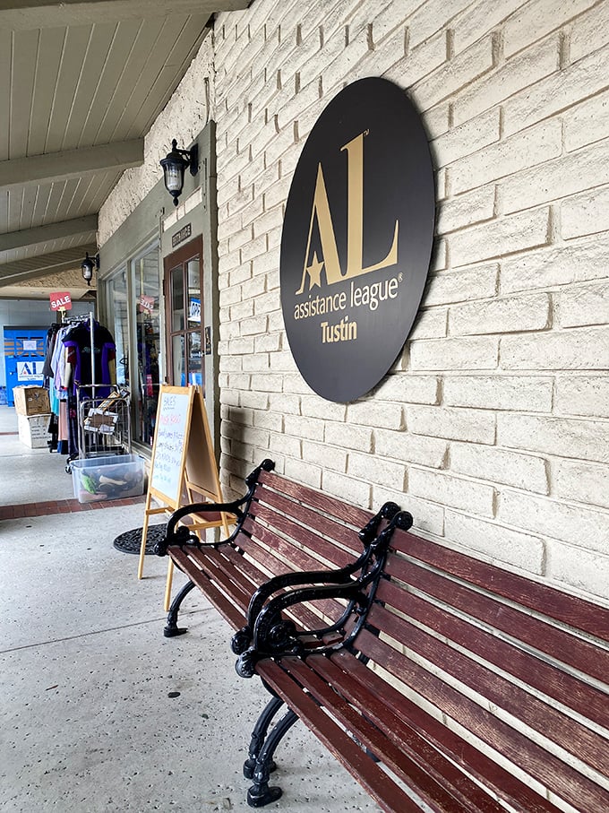 The welcoming bench beneath the Assistance League sign – the perfect spot to rest while your shopping companion "just needs five more minutes."