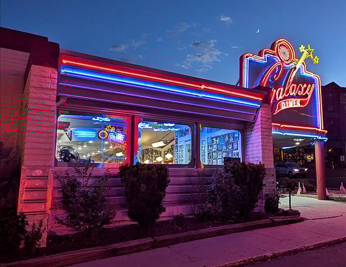 At night, Galaxy Diner transforms into a neon-drenched dream, glowing like a spaceship that landed on Route 66 and decided to serve up the best milkshakes in the galaxy.