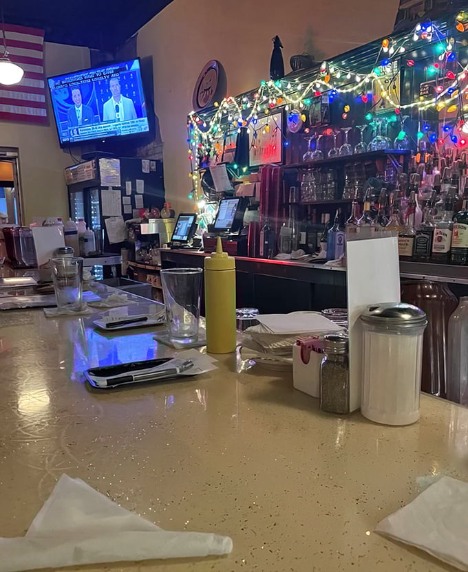 The bar where regulars have worn grooves in the counter—Christmas lights twinkling year-round above bottles of liquid comfort.