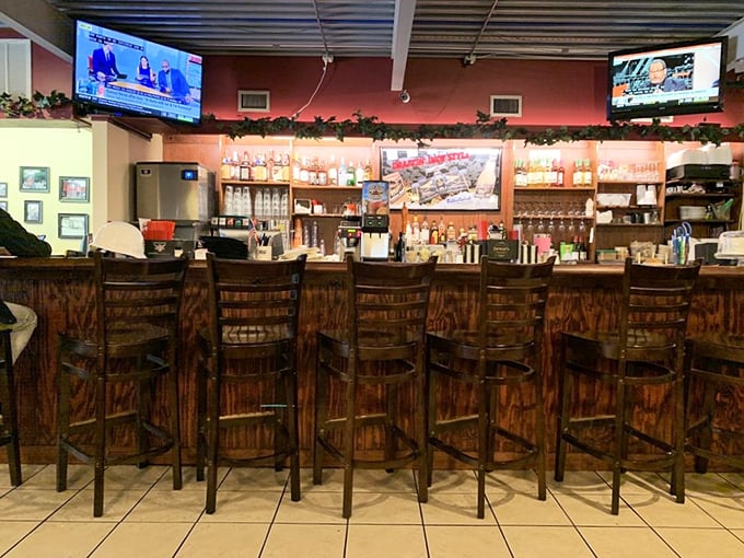 The bar area—where strangers become friends and friends become family. Wood stools that have heard it all and TVs that ensure you never miss the game.