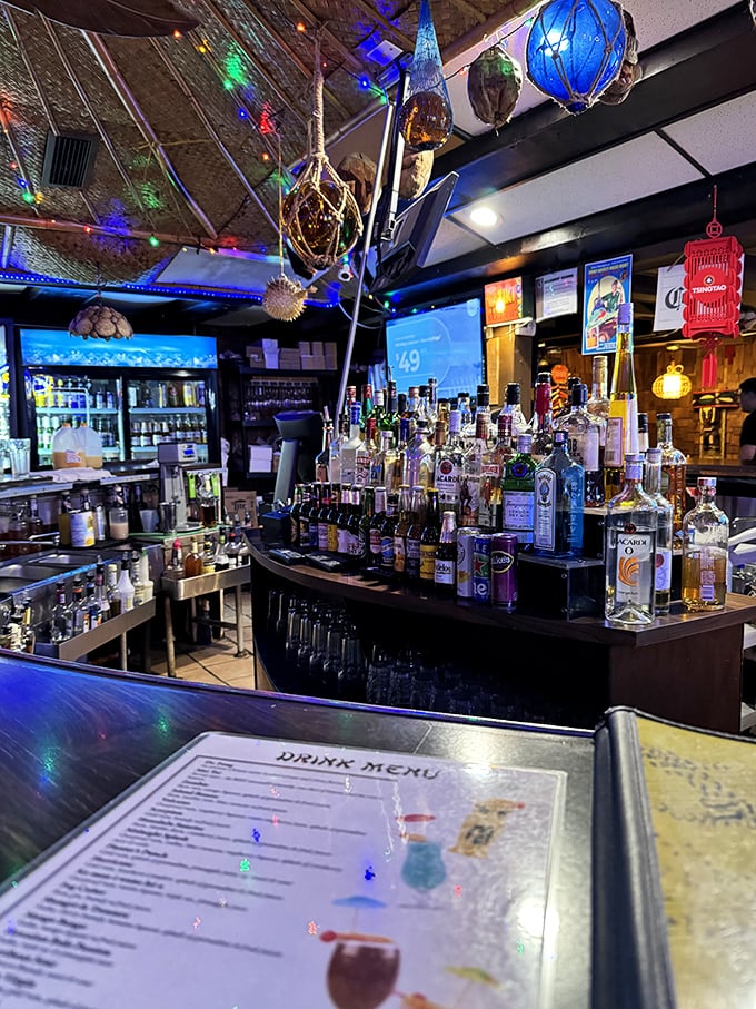 The bar where liquid vacation is served daily. That impressive lineup of bottles isn't just decoration—it's an arsenal of tropical escape mechanisms.