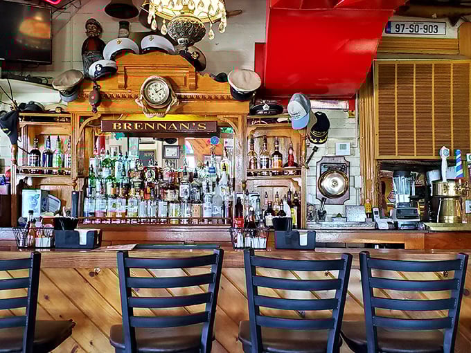 The bar at Brennan's isn't just where drinks are made—it's a maritime museum where sailors' caps and memorabilia tell stories of adventures past.