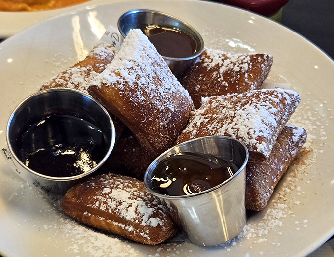 These beignets aren't just dessert—they're little powdered pillows of joy, served with dipping sauces that make you wonder why you'd ever waste time on lesser sweets. 