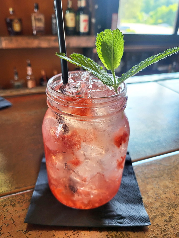 A berry-infused cocktail that's practically wearing a garden on its head. That fresh mint isn't just garnish – it's aromatherapy with benefits.