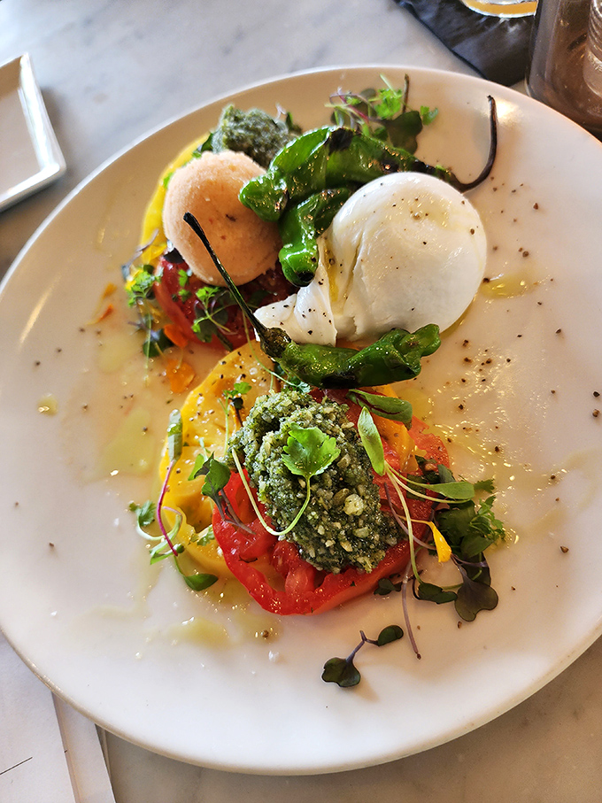 The burrata plate demonstrates that sometimes the simplest hypothesis—fresh ingredients arranged with care—yields the most spectacular results.
