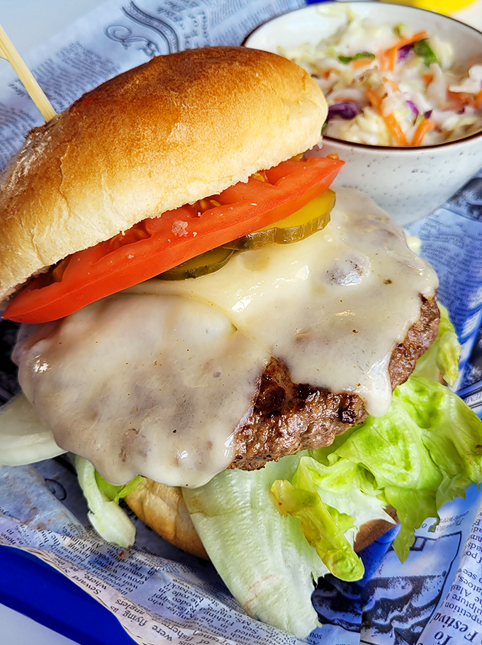 A cheeseburger that doesn't need Instagram filters—melty cheese cascading over a perfectly seared patty with garden-fresh toppings.