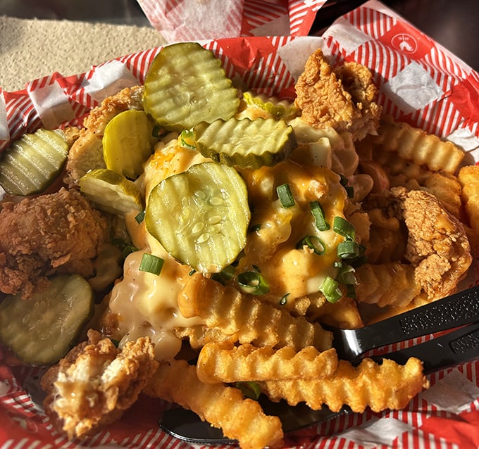Crinkle-cut fries smothered in cheese with chicken bites and pickles isn't a snack—it's what happens when comfort food gets dressed for a Nashville night out.