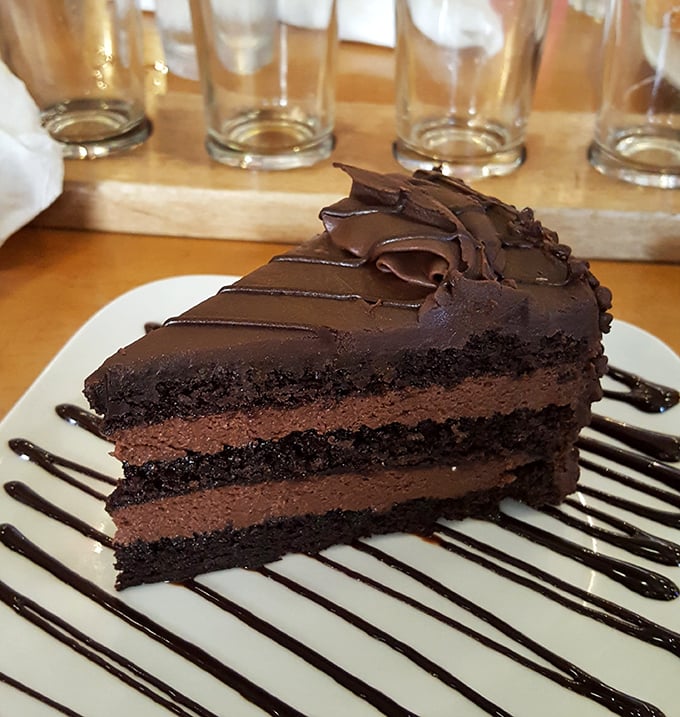 Chocolate cake so rich it probably owns real estate in three states. Fork required, sharing optional, regrets impossible.