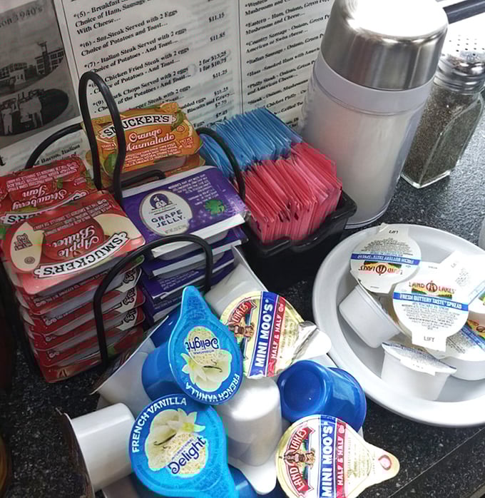 The condiment caddy—civilization's greatest achievement. These humble packets and creamers are the supporting cast that turns good meals into personal masterpieces.
