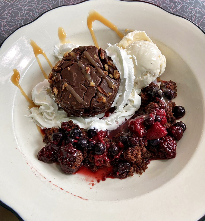 Dessert that's worth saving room for—a chocolate masterpiece surrounded by berries that technically makes it count as fruit, right?