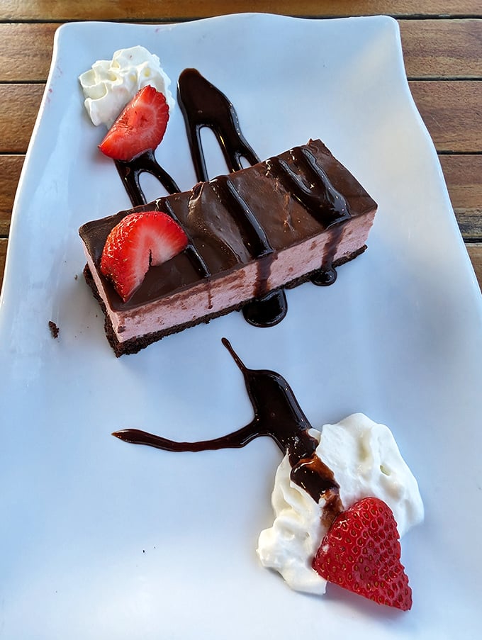 Chocolate layered dessert with fresh strawberries—because after all that seafood, your sweet tooth deserves its moment in the spotlight too.