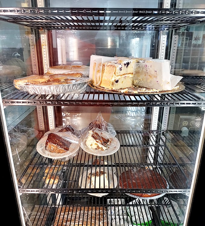 The dessert case—where willpower goes to die and happiness begins. That cheesecake has witnessed countless "just one bite" promises.