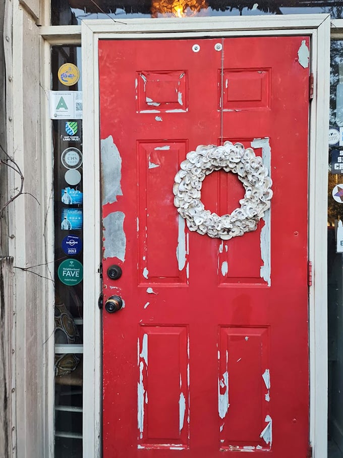 That weathered red door with its oyster shell wreath isn't just an entrance – it's a portal to one of South Carolina's most beloved seafood experiences.