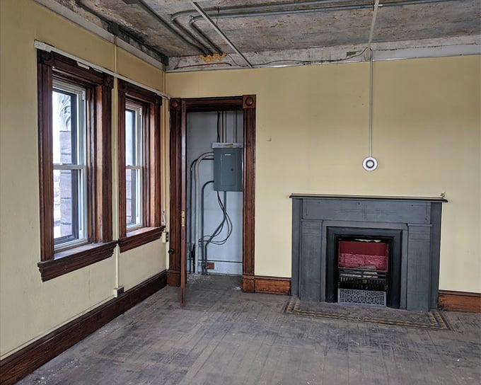 The sheriff's quarters offered relative luxury with wooden trim, large windows, and this fireplace—a stark contrast to the spartan cells just steps away.