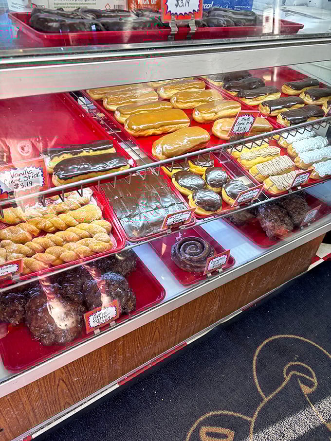 The display case—a museum of fried artistry where each shelf offers a different exhibition of donut craftsmanship.
