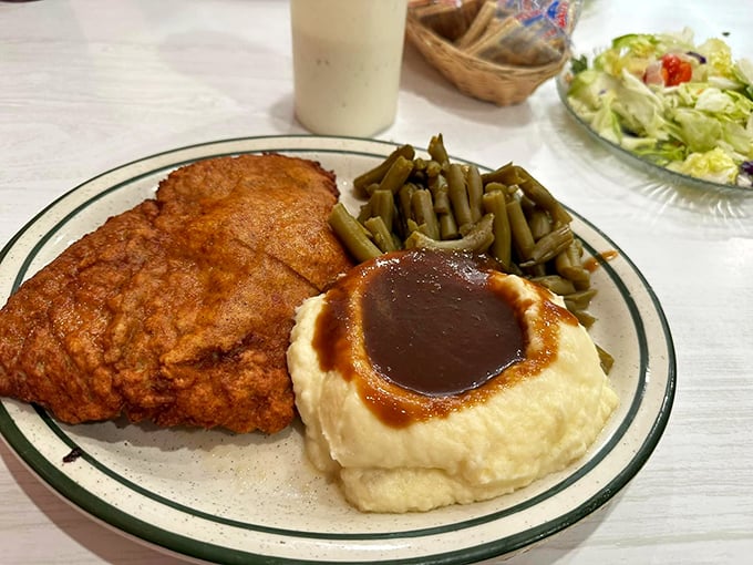 Crispy fried chicken, garden-fresh green beans, and gravy-topped mashed potatoes – the plate that launched a thousand road trips to Golden City.
