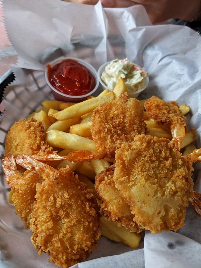 The jumbo shrimp basket arrives like a golden treasure chest—crispy crustaceans and perfect fries flanked by coleslaw and cocktail sauce for dipping adventures.