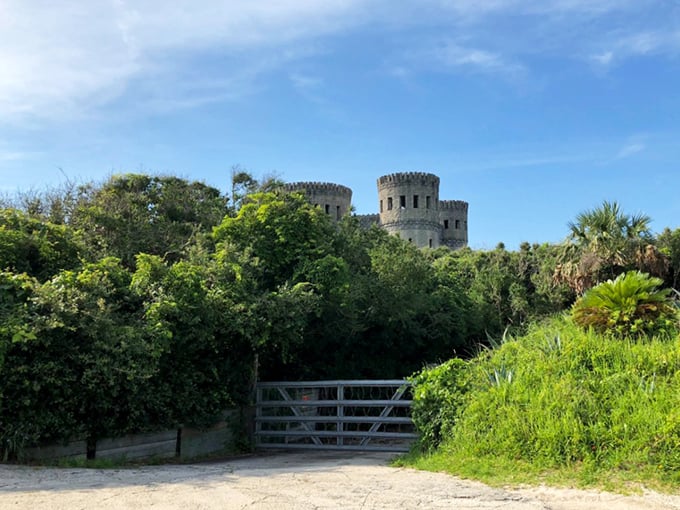 Beyond the rustic gate, Castle Otttis rises from the landscape—a stone mirage that seems to float above the Florida greenery.