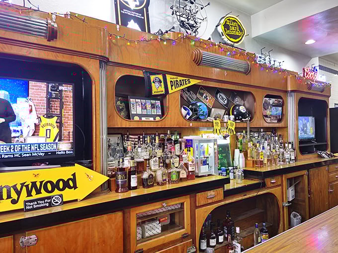 The bar area showcases Pittsburgh sports memorabilia and cold beverages—the perfect complement to a sandwich that requires serious dedication to finish.