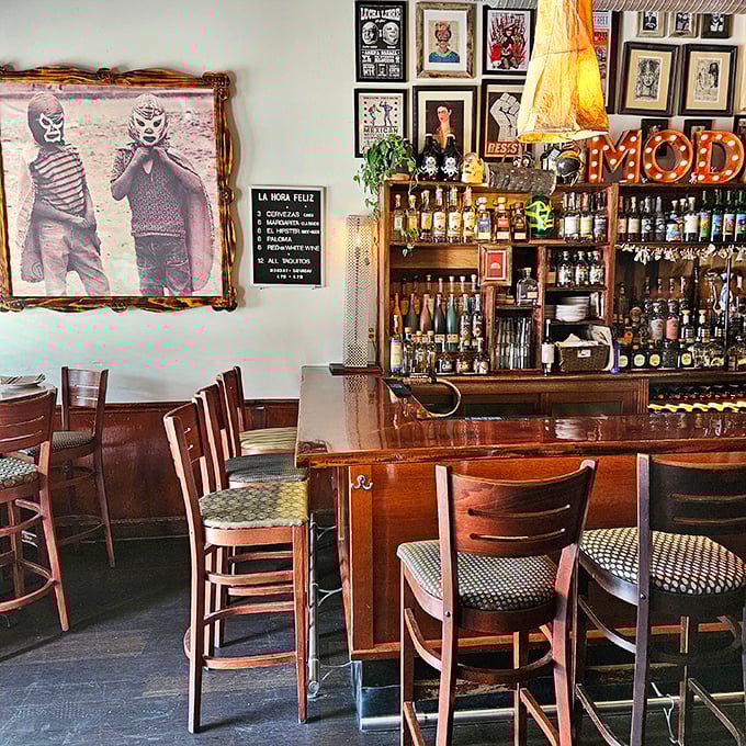 Vintage Mexican wrestling imagery watches over diners—silent guardians of a bar area that balances quirky nostalgia with serious tequila business.