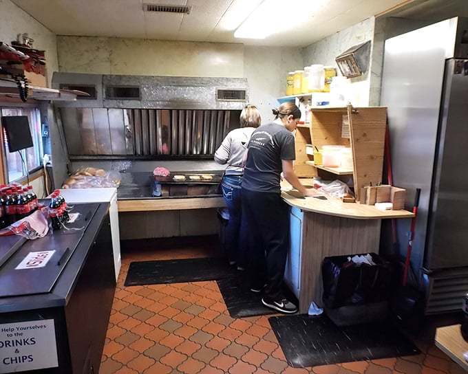 Behind the scenes, the kitchen's modest equipment proves you don't need fancy gadgets to create legendary burgers—just skill, tradition, and a well-seasoned grill.