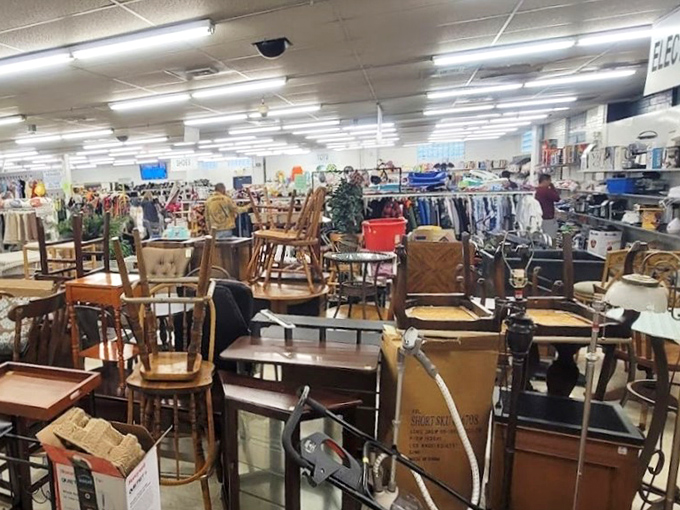 The furniture graveyard that's actually a rebirth center. Dining sets, side tables, and chairs patiently wait for someone to see their potential beneath the 1970s veneer.
