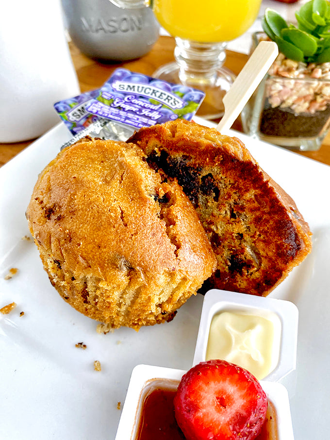 A muffin that looks like it could win a bake-off, served with butter and jam because some traditions should never change.
