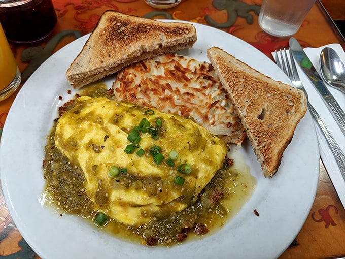 This isn't your average omelet—it's a golden envelope delivering a message of flavor, served with perfectly crispy hash browns and toast.