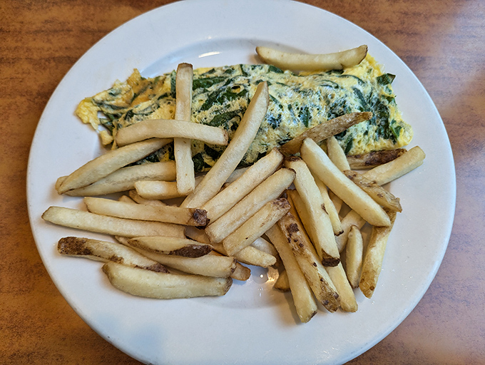 The spinach omelet and fries combo—proof that breakfast foods have no respect for arbitrary mealtime boundaries, and we're all better for it.