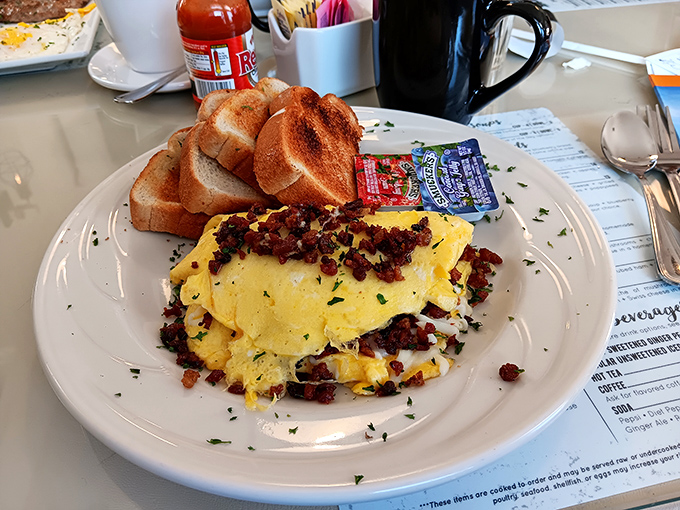 An omelet that's clearly showing off for the camera. Those crispy bits of bacon mixed throughout aren't just ingredients—they're tiny flavor bombs.