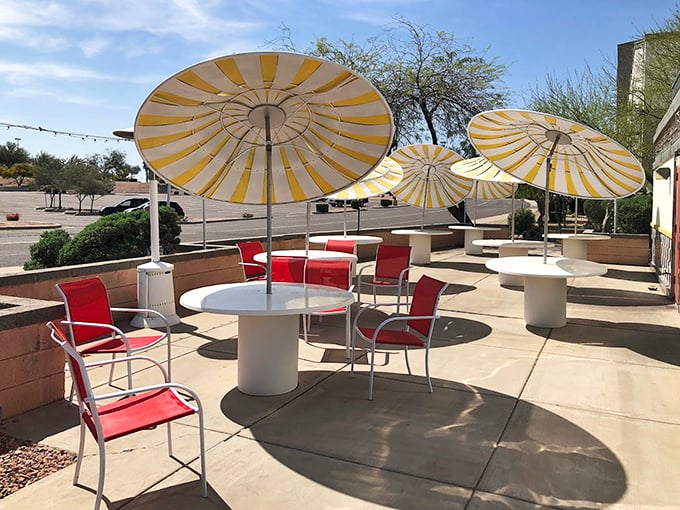 The outdoor patio with its cheerful yellow umbrellas offers a sun-dappled alternative for enjoying diner classics under Arizona's famous blue skies.