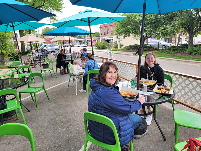 Outdoor dining that captures Madison's neighborhood charm. Blue umbrellas, green chairs, and food worth smiling about—summer in Wisconsin distilled.