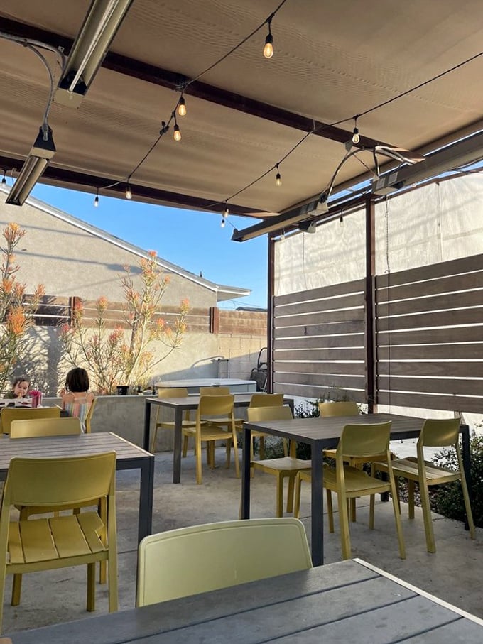 The outdoor patio – where string lights, yellow chairs, and LA sunshine create the perfect backdrop for your food coma recovery.