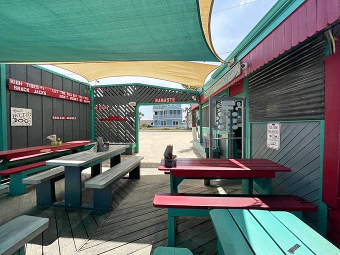 Outdoor seating painted in beachy turquoise and red, where the salt air serves as a complimentary appetizer to whatever you've ordered.