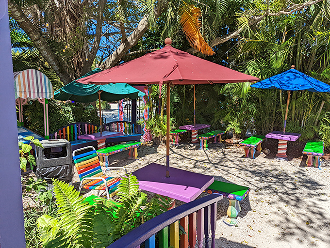 The outdoor patio brings the party outside, where colorful umbrellas shade tables surrounded by tropical greenery and whimsy.