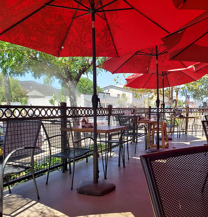The patio basks under red umbrellas, offering fresh air with your feast and mountain views for dessert.