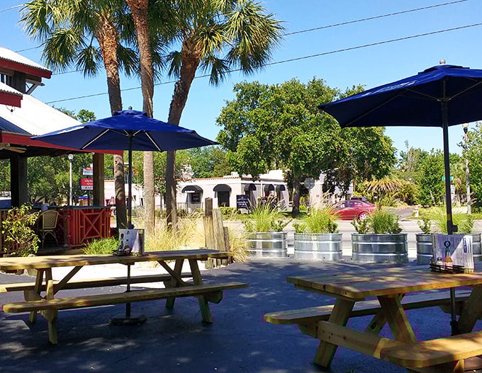 Florida dining as nature intended. These outdoor picnic tables under blue umbrellas aren't just seating—they're front-row tickets to sunshine and satisfaction.