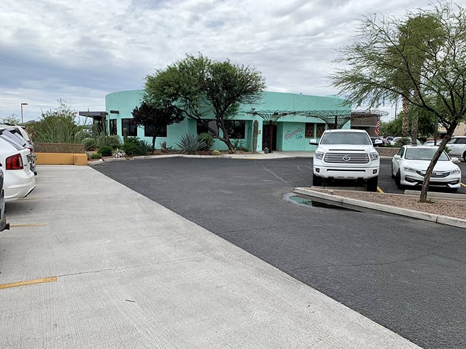 Even the parking lot wears turquoise with pride. Desert landscaping frames this culinary oasis, promising air-conditioned relief and delicious rewards inside.